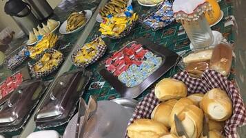 Buffet com diversos alimentos e utensílios.