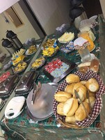 Buffet com diversos alimentos e utensílios.