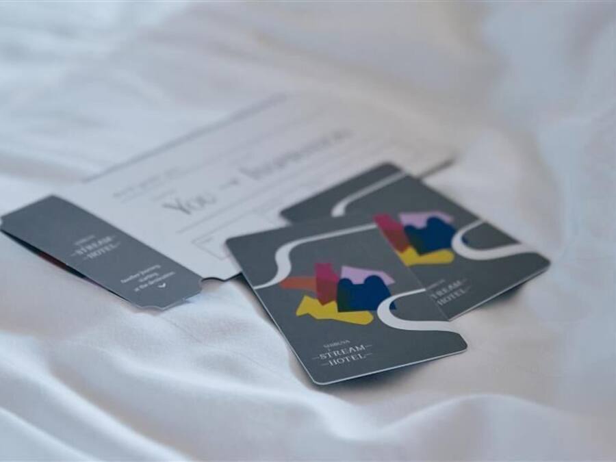 Um folheto de hotel com design moderno, apresentando uma paisagem urbana estilizada e o nome do hotel.