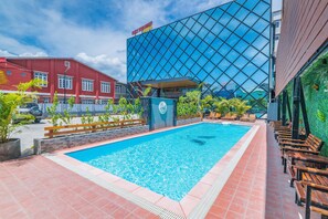 Piscina com um edifício vermelho ao fundo.