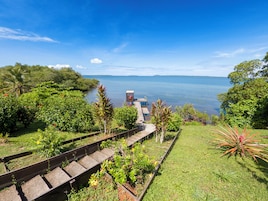 Um jardim com um deck de madeira com vista para um lago.