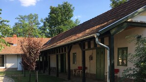 Um edifício com telhado em cerâmica, um pátio coberto e um pátio interno gramado.
