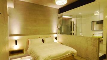 Quarto moderno com uma cama grande, uma mesa de cabeceira, um espelho e um lustre.