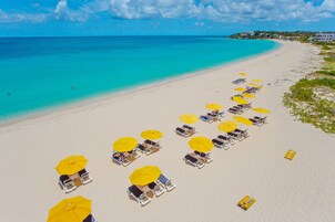 Na praia, praia de areia branca, espreguiçadeiras, guarda-sóis de praia 