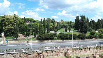 Sítio arqueológico com ruínas antigas e uma estrada moderna em primeiro plano.