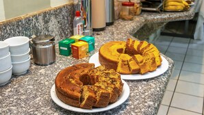 Um balcão de buffet com diversos alimentos e acompanhamentos.