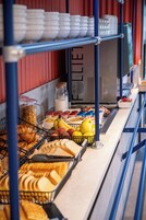 Disposição de buffet com diversos alimentos e acompanhamentos.