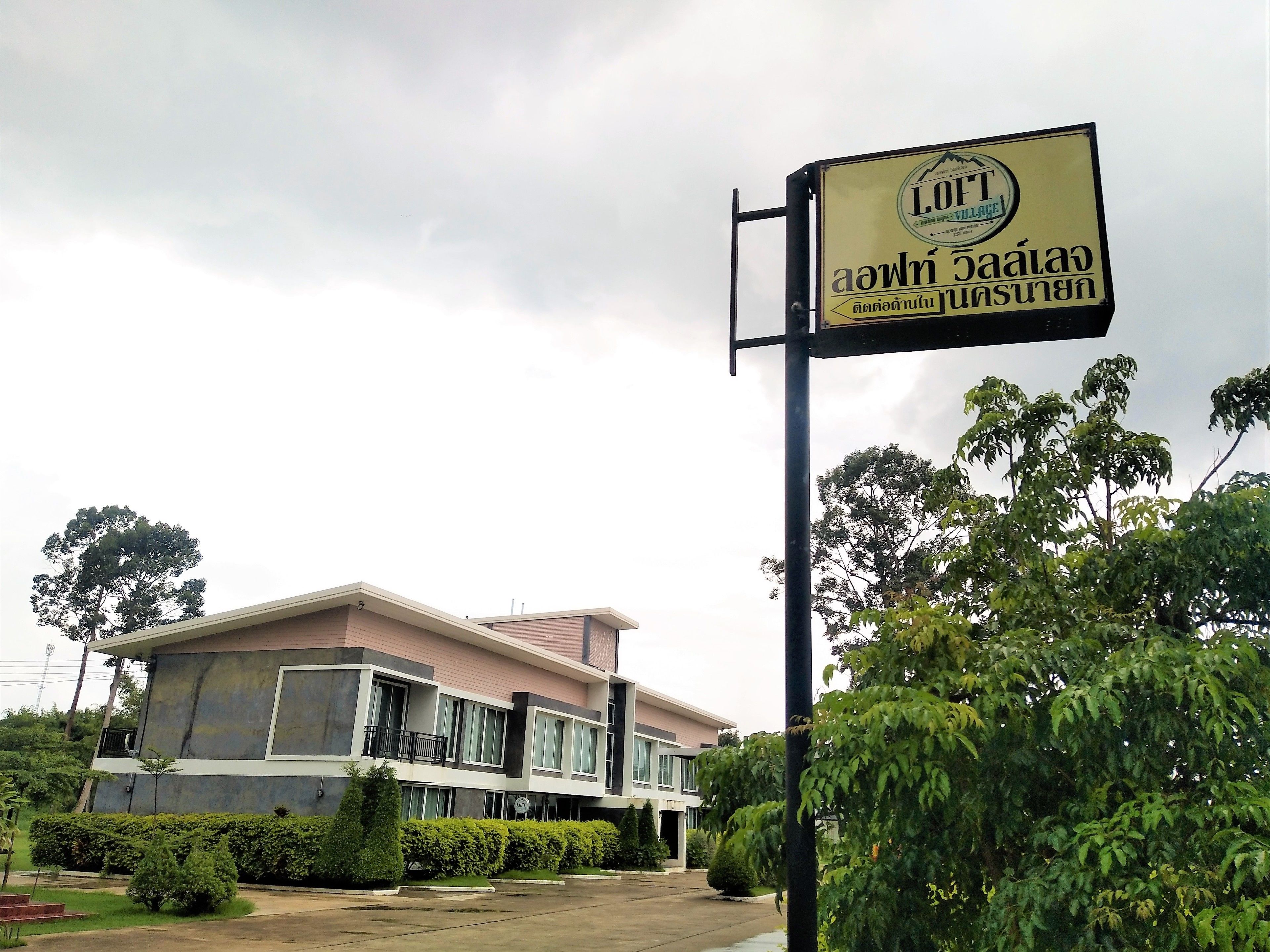 Um edifício moderno com uma placa indicando ser um hotel na vila.