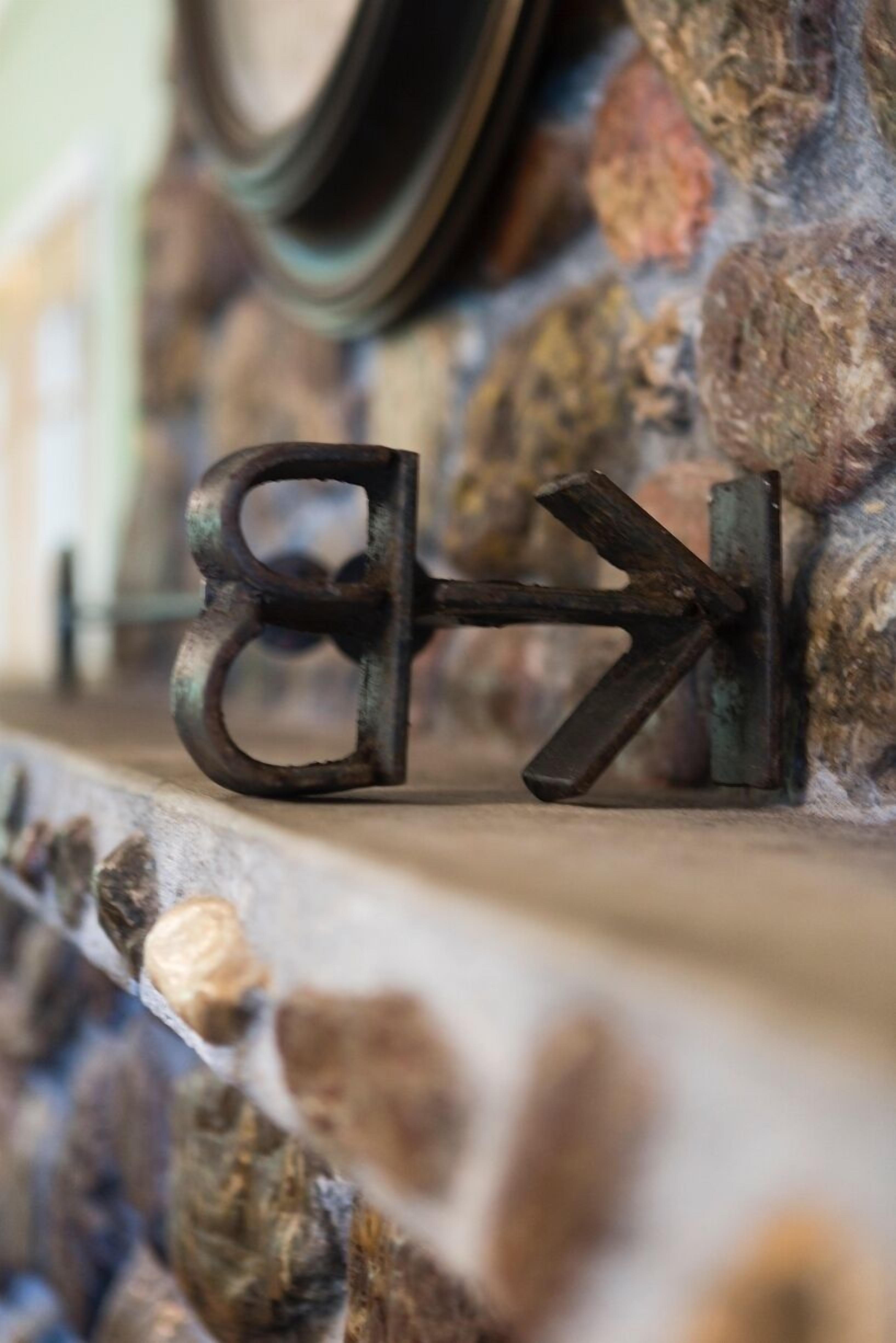 Uma placa de metal com as letras "K" e "B" em uma parede de pedra.