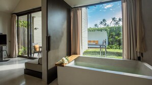 Uma casa de banho moderna com uma banheira grande, uma porta de correr de vidro para uma varanda e um design minimalista.