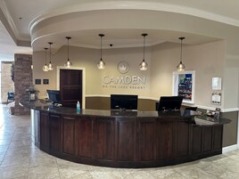 Uma receção com design curvo, vários monitores e iluminação pendente.