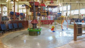 Espaço de recreação infantil com fonte, assentos e estrutura de escalada.