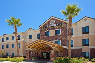 Um hotel Staybridge Suites com fachada de tijolos, várias janelas e entrada coberta.
