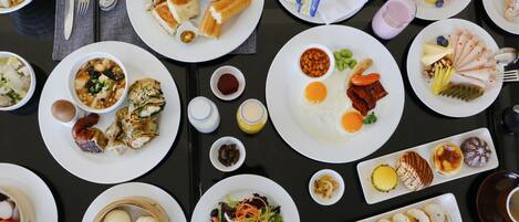 Mesa posta com diversos pratos, incluindo sopa, sanduíches e salada.