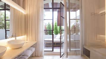 Casa de banho com uma pia grande, uma banheira e uma janela com cortinas.