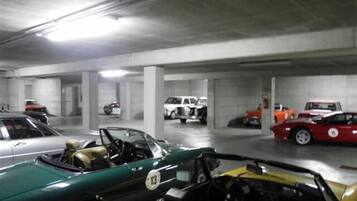 Um parque de estacionamento com vários andares e diversos carros estacionados.