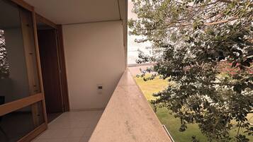 Varanda com vista para um espaço gramado e árvores.