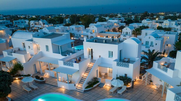 Uma villa branca moderna com piscina, várias varandas e áreas de estar ao ar livre.