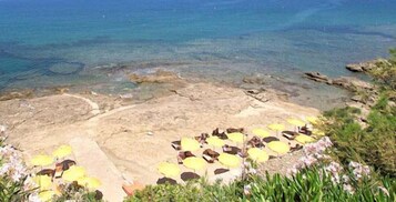 Uma praia privada, espreguiçadeiras, guarda-sóis de praia