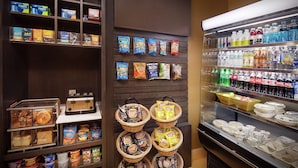 Uma área de café da manhã com diversos alimentos, incluindo pão, doces e lanches.