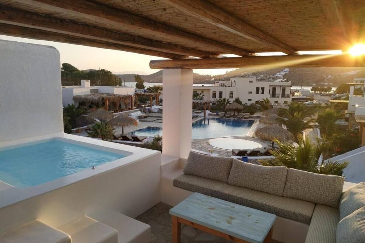 Terraço no topo do prédio com banheira de hidromassagem, sofá e mesa.