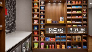 Exposição de lanches no hall de um hotel, com diversas marcas de batatas fritas e petiscos.