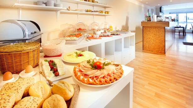 Buffet com diversos pratos e uma estação de grelhados.