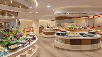 Disposição moderna de buffet com diversas estações de serviço, incluindo uma variedade de alimentos e elementos decorativos.