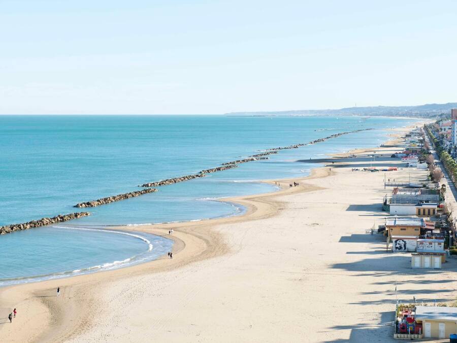 Uma praia privada, espreguiçadeiras, guarda-sóis de praia