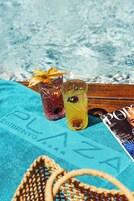 Duas bebidas sobre uma toalha azul, com uma revista ao lado.