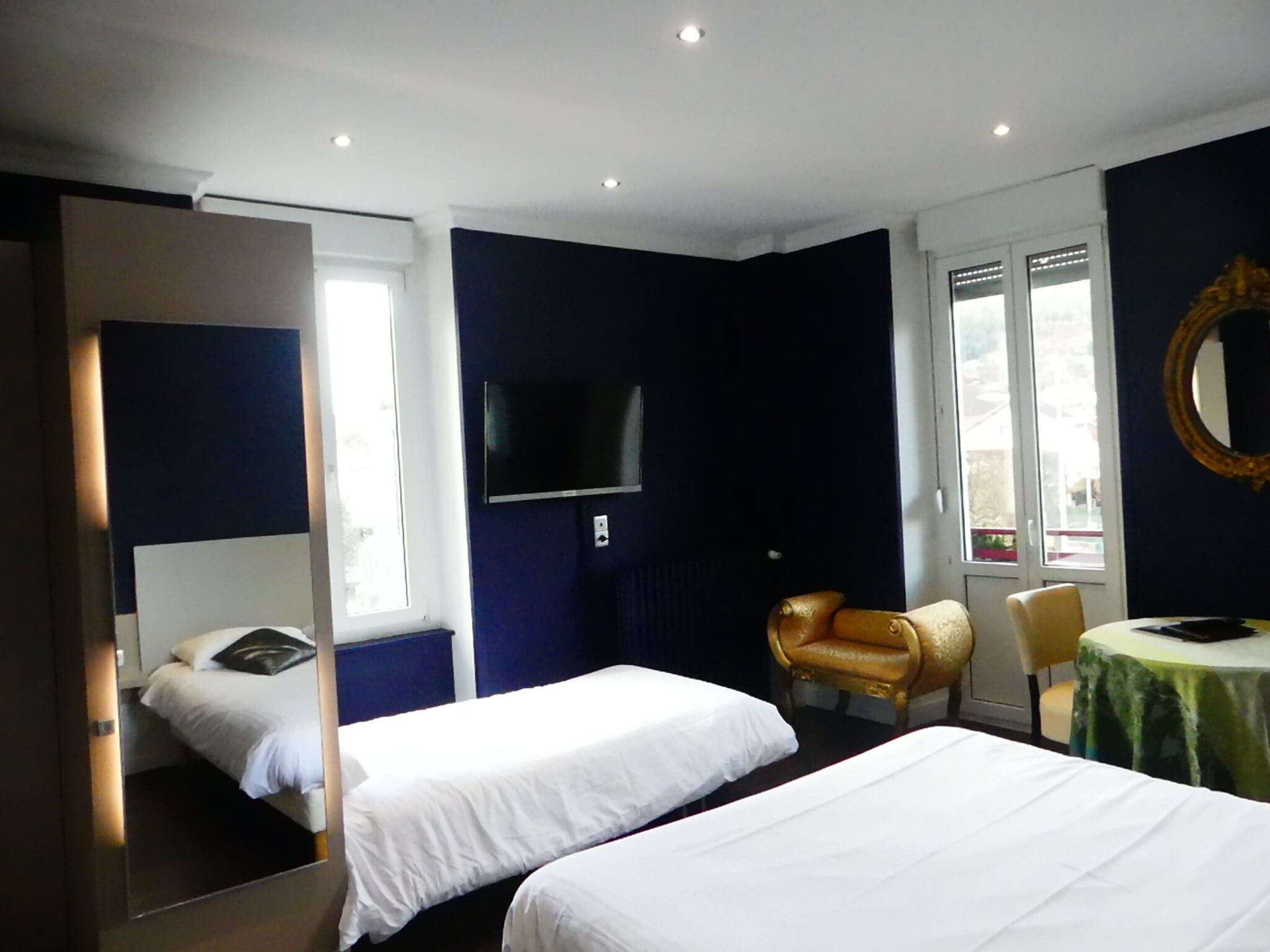 Quarto de hotel com duas camas, televisão, uma cadeira e uma mesa.