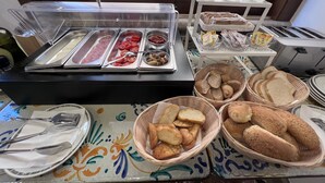 Buffet com diversos alimentos, incluindo carnes, vegetais e pães.