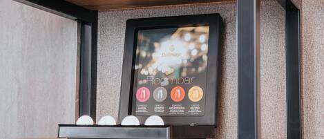 Um menu Roombar emoldurado com opções de café e uma máquina de café logo abaixo.