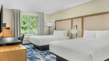 Quarto de hotel com duas camas, uma escrivaninha, uma cadeira, uma televisão e uma janela com cortinas.