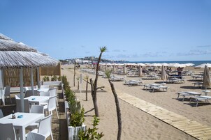 Uma praia privada, espreguiçadeiras, guarda-sóis de praia 