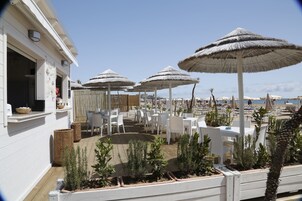 Uma praia privada, espreguiçadeiras, guarda-sóis de praia 