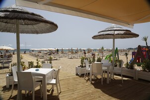 Uma praia privada, espreguiçadeiras, guarda-sóis de praia 