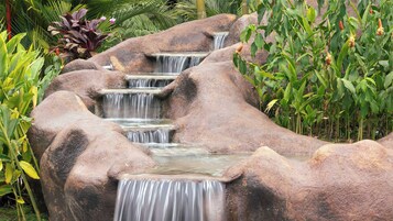 Uma cascata de rocha cercada por vegetação exuberante.