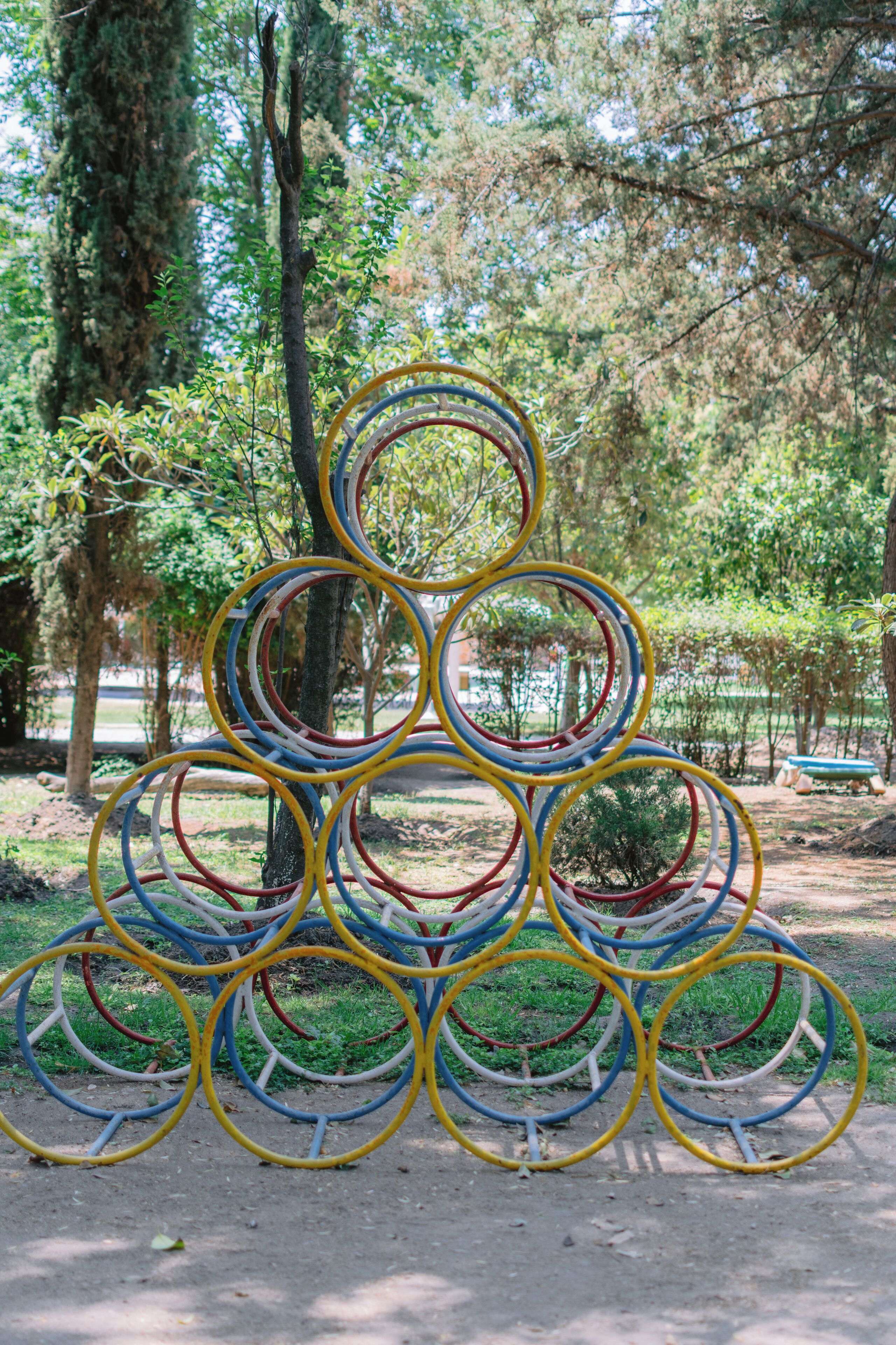 Escultura de aros interligados em um parque.