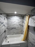 Quarto Individual Deluxe | Casa de banho | Uma combinação polibã/banheira, toalhas fornecidas 