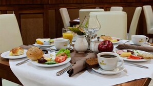 Um buffet de café da manhã com diversas opções de alimentos, incluindo pães, frutas, vegetais e bebidas.