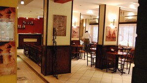 Interior de restaurante com cabines, mesas e um bar.