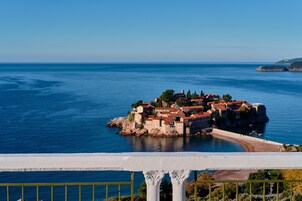 Uma vila costeira com edifícios históricos, uma praia e uma estrutura fortificada.