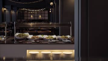 Disposição de buffet com várias travessas de comida e pratos empilhados, iluminada por luzes sob a bancada.