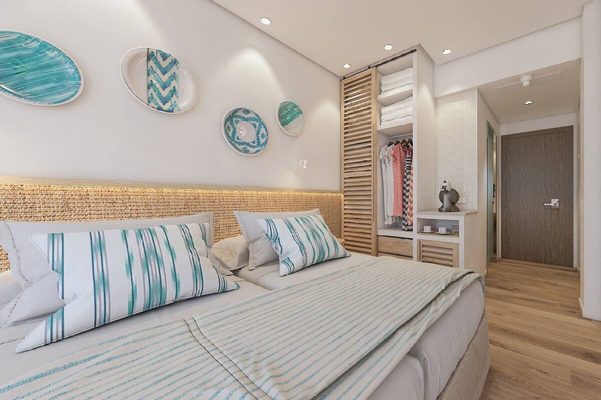 Quarto moderno com cama grande, cabeceira de madeira e roupeiro embutido com espaço para pendurar.