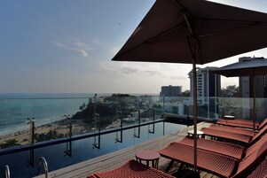 Piscina no terraço com vista para a praia e o oceano.