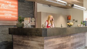 Uma receção de hotel com uma placa a indicar "AlpenParks HOTEL & APARTMENT CENTRAL ZELL AM SEE".
