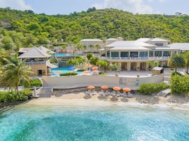 Um resort com piscina, praia e vegetação exuberante.