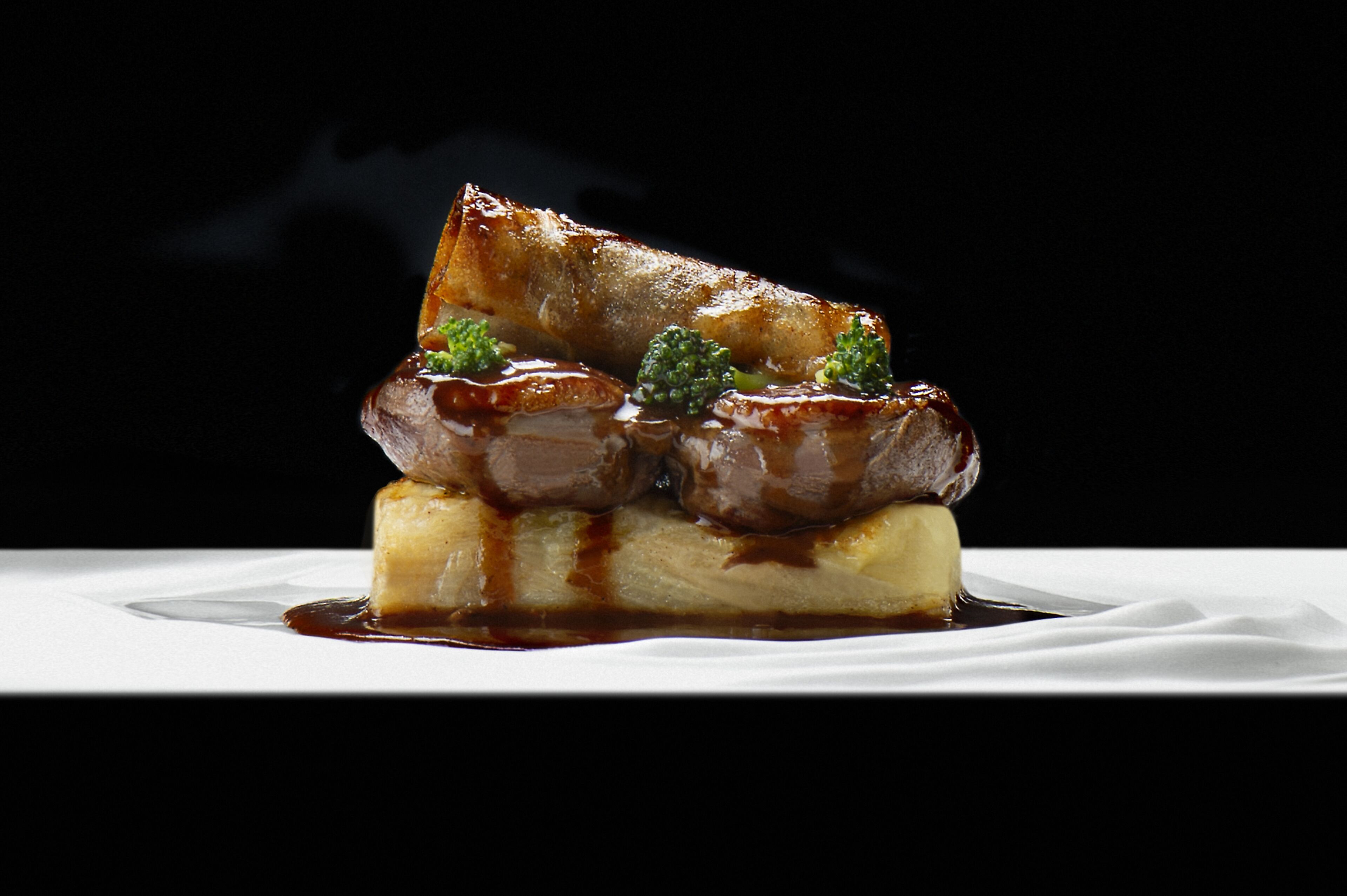 Prato com carne e brócolis sobre um prato branco.