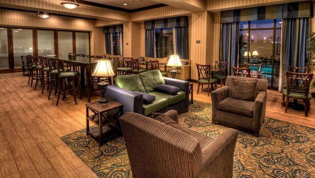 Um hall amplo com área de refeições, diversas opções de assento e vista para o exterior.